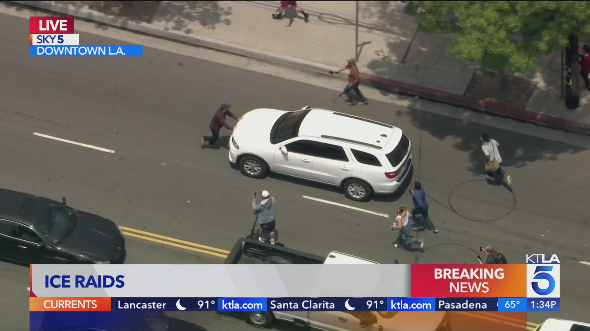 Protester tries to stop ICE SUV from leaving site of raid in L.A ...